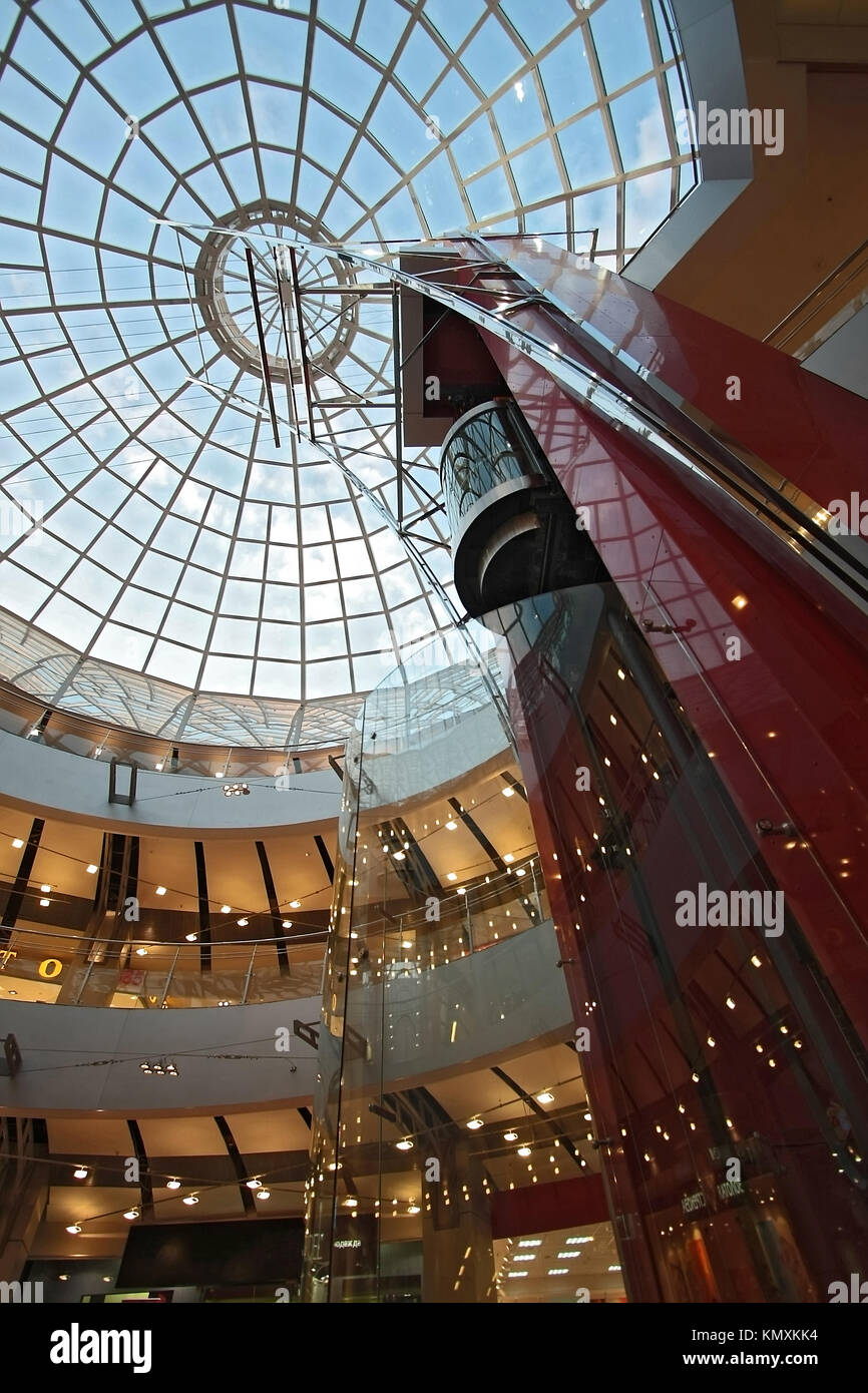 Huge hall of modern shopping centre with the glass lift and a ...