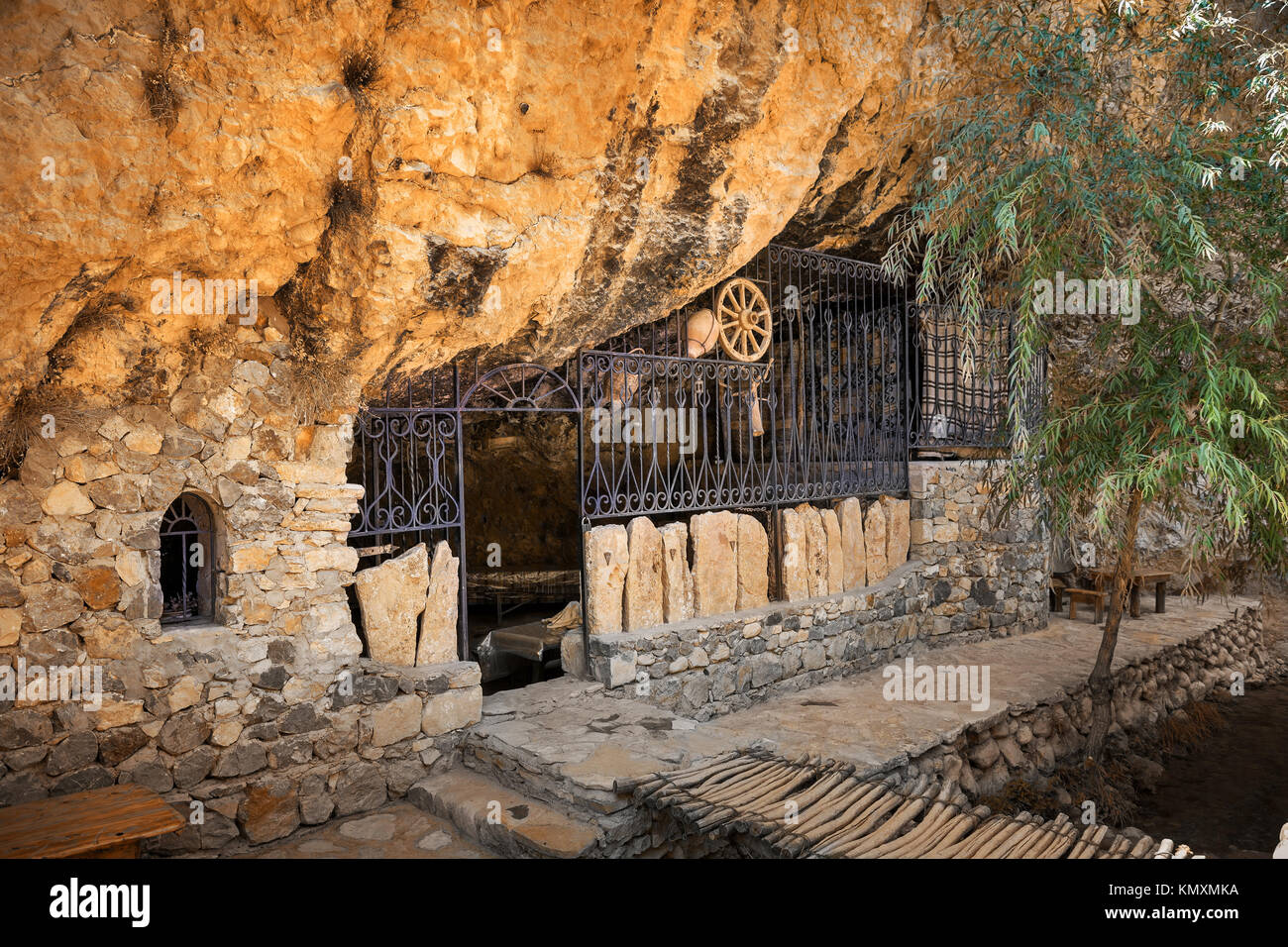 The grotto in the rock which is fenced off by a wall with a lattice and ...