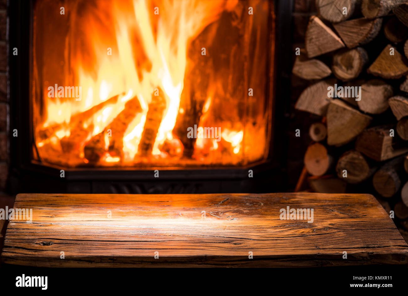 Old wooden table and fireplace with warm fire at the background Stock ...