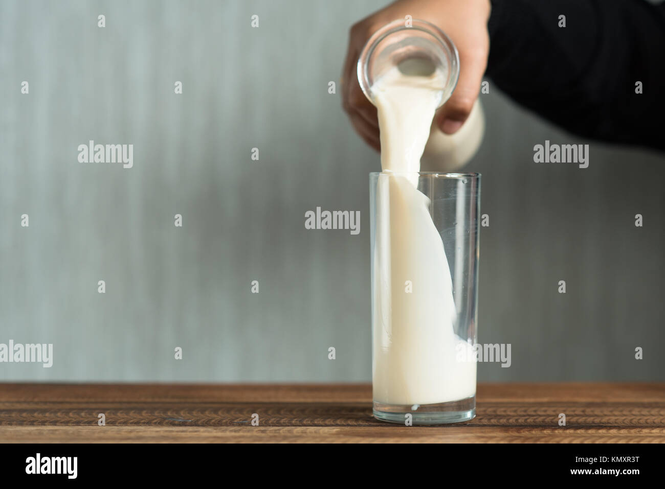 pouring milk into glass. filling a glass with milk Stock Photo - Alamy