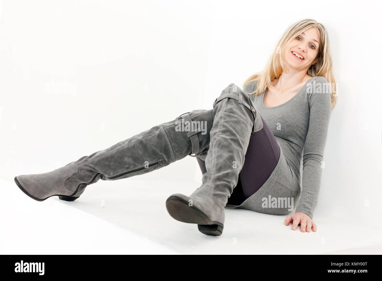 sitting woman wearing fashionable gray boots Stock Photo - Alamy