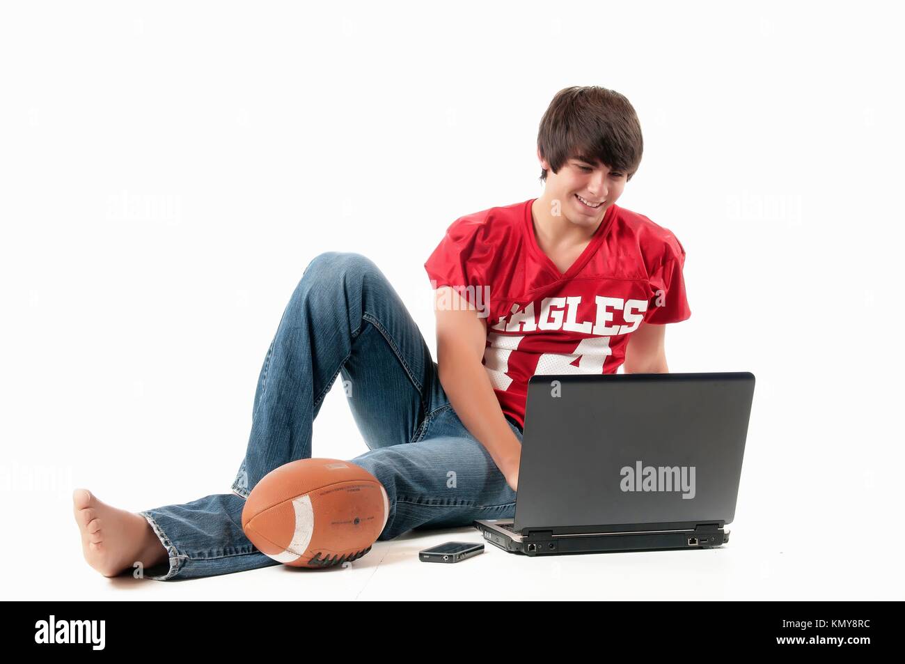 Teenage Boy with football working laptop computer Stock Photo - Alamy