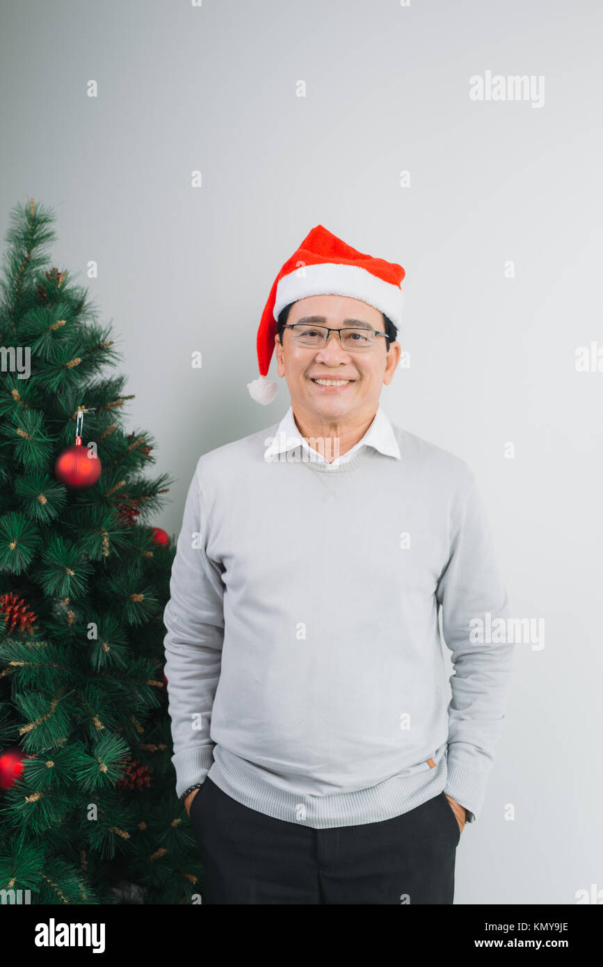 Happy senior asian man standing by christmas tree at home Stock Photo ...