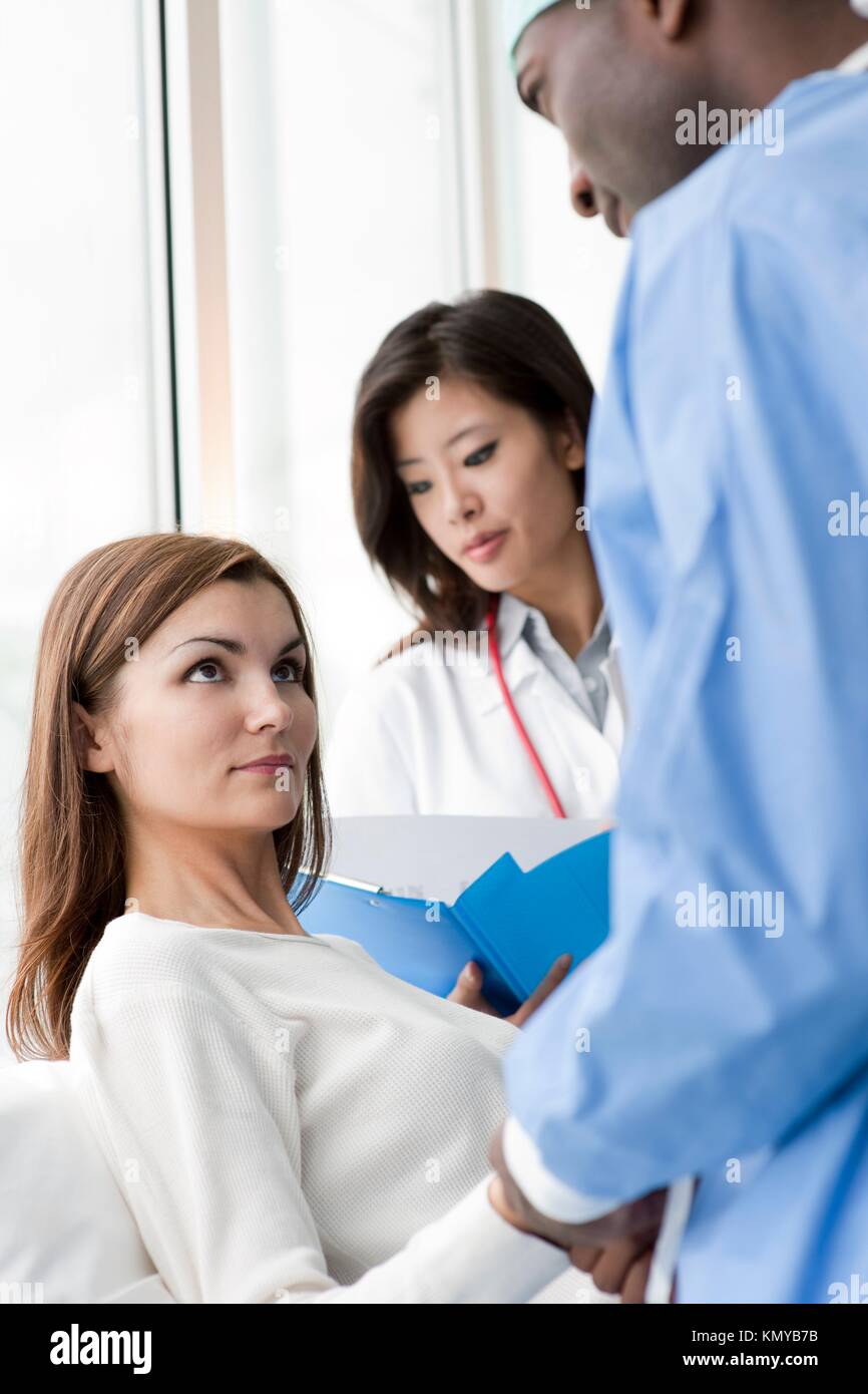 Doctor and surgeon speaking with a female patient Stock Photo - Alamy