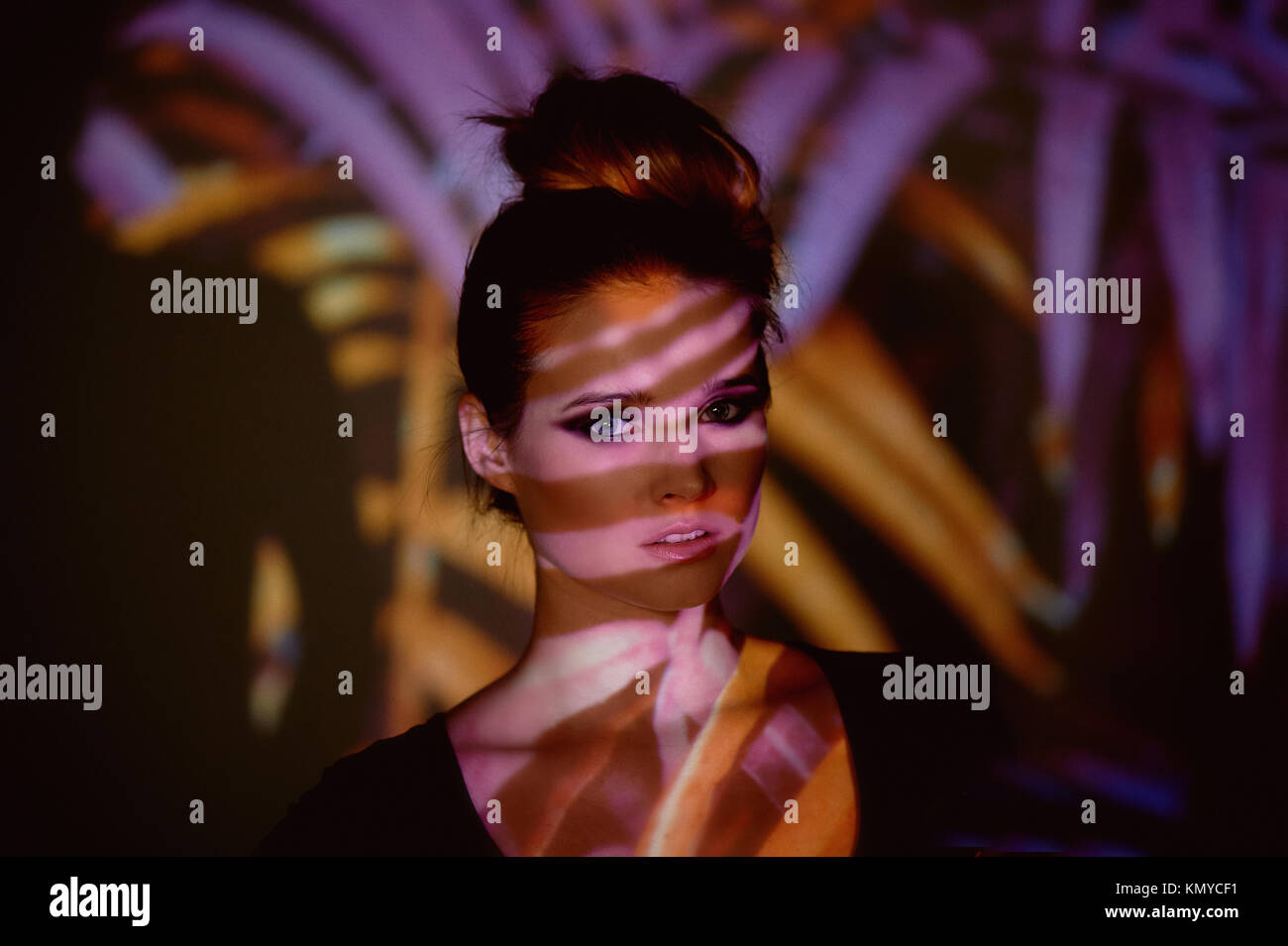 Abstract portrait of a beautiful girl in the light of the projector ...