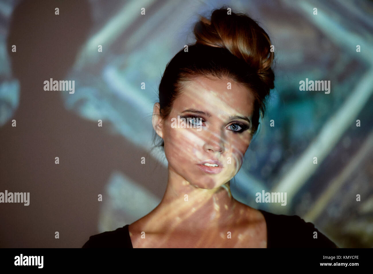 Abstract portrait of a beautiful girl in the light of the projector ...