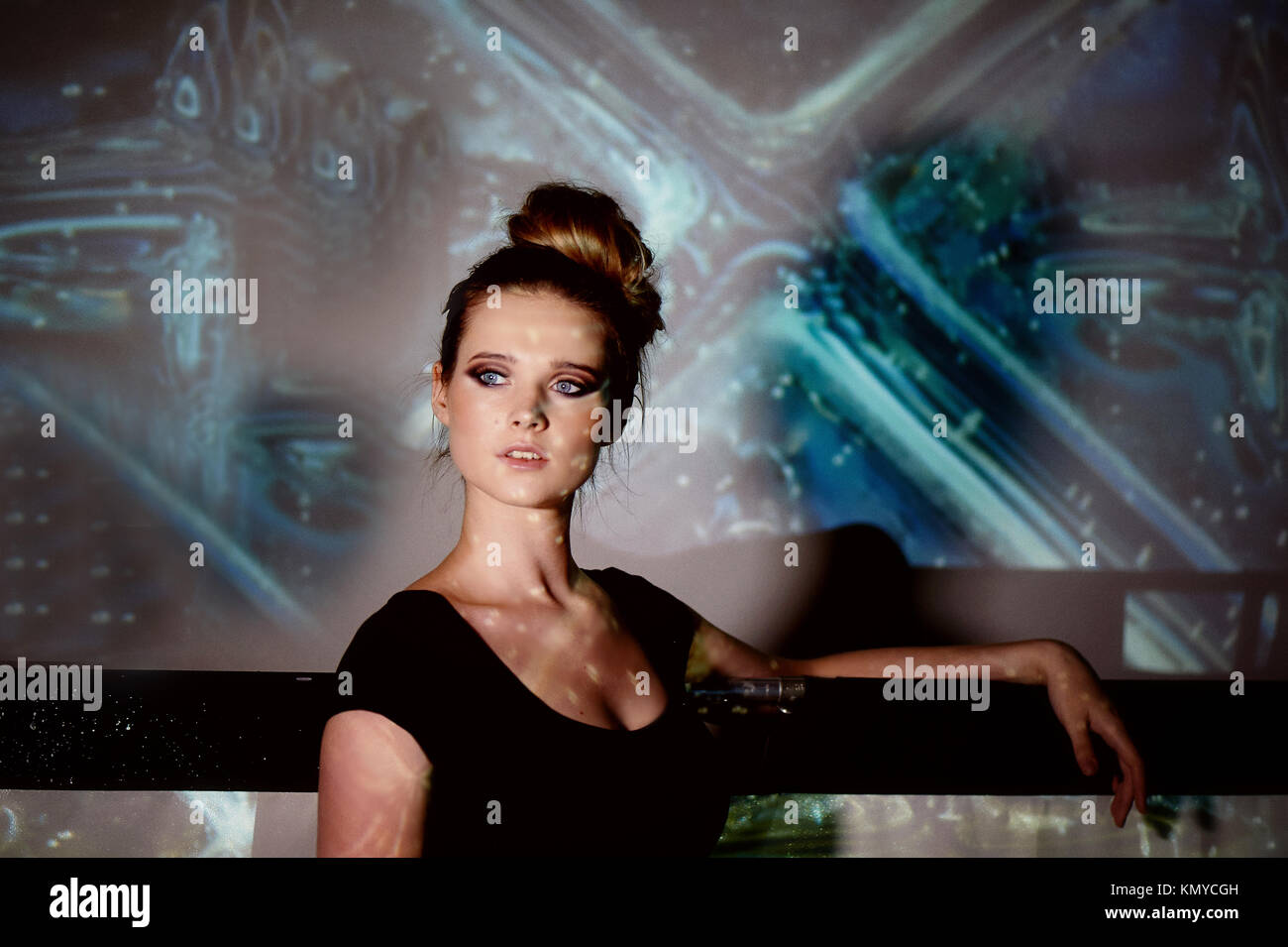 Abstract portrait of a beautiful girl in the light of the projector ...