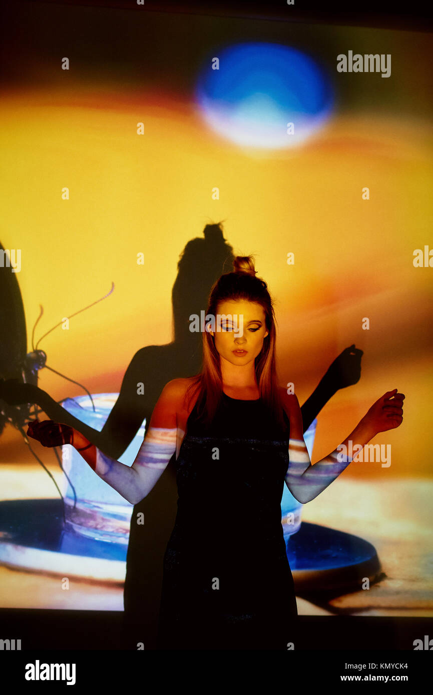 Abstract portrait of a beautiful girl in the light of the projector ...