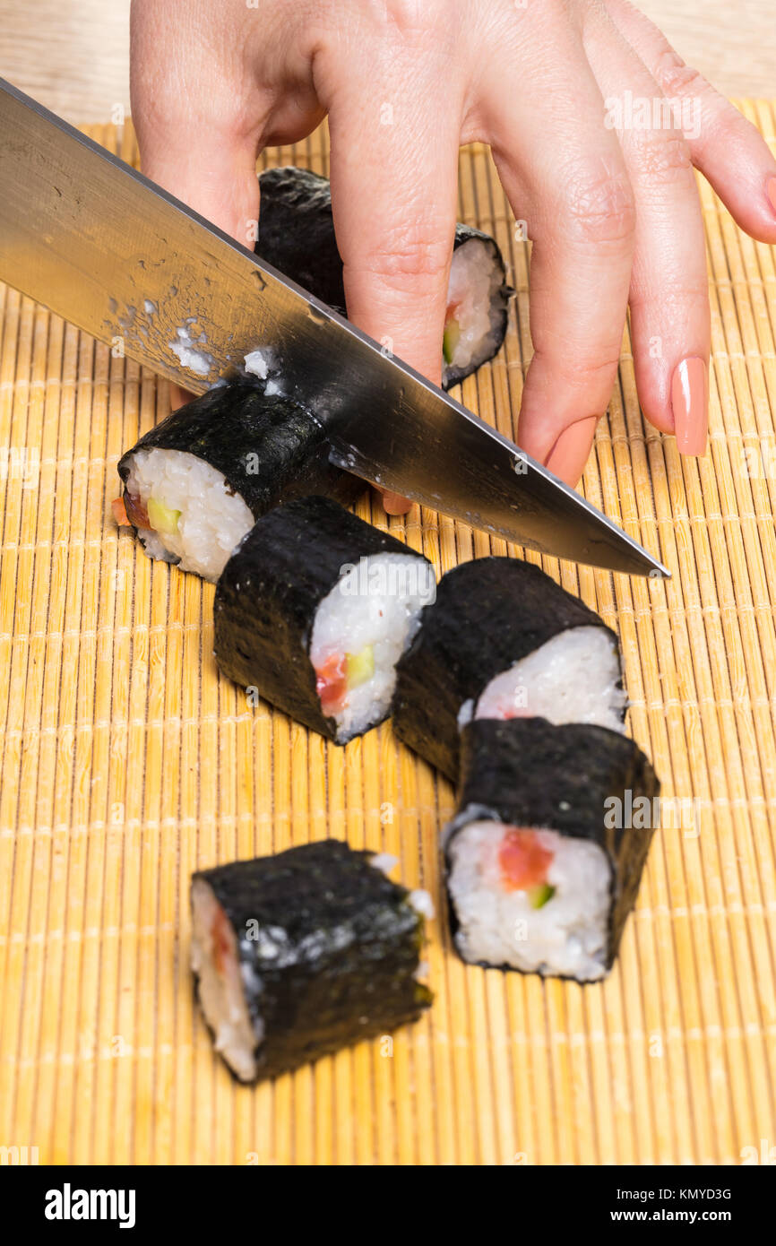 Japanese cuisine. Chef cuts rolls, hands close-up Stock Photo - Alamy