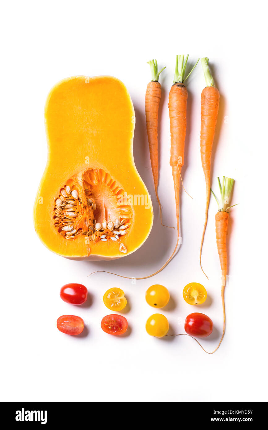 Set of whole and sliced red, orange and yellow vegetables over white ...