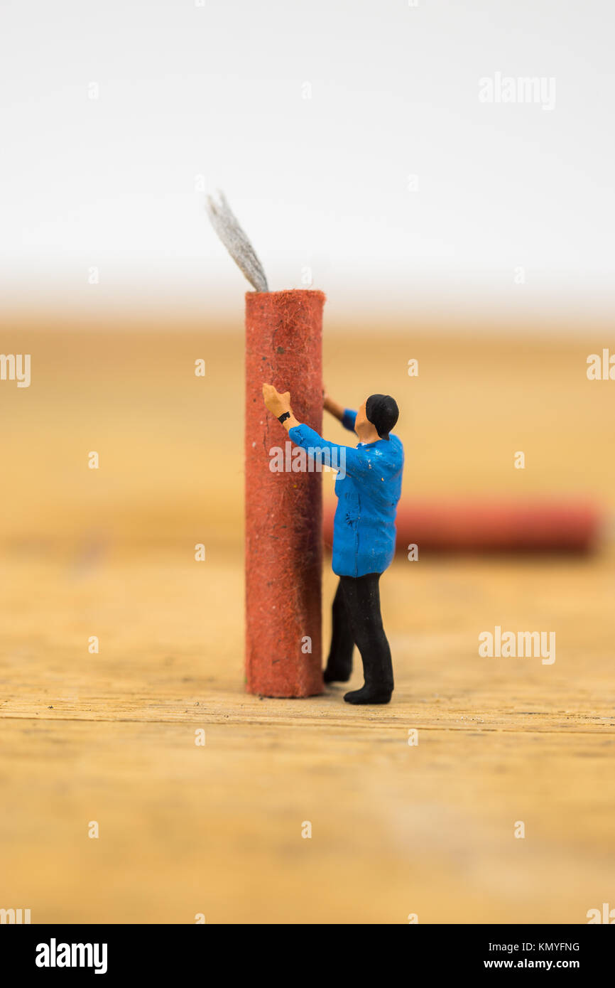 Concept miniature people working hard on Firecracker Stock Photo - Alamy
