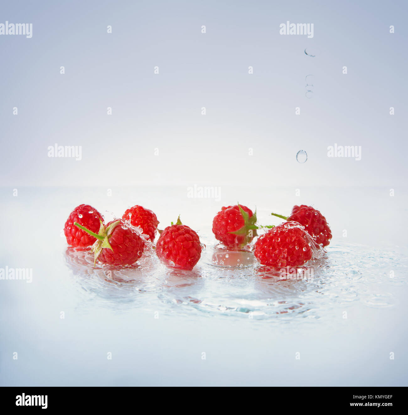 Juicy fresh raspberries dropped to blue clear water with splash Stock ...