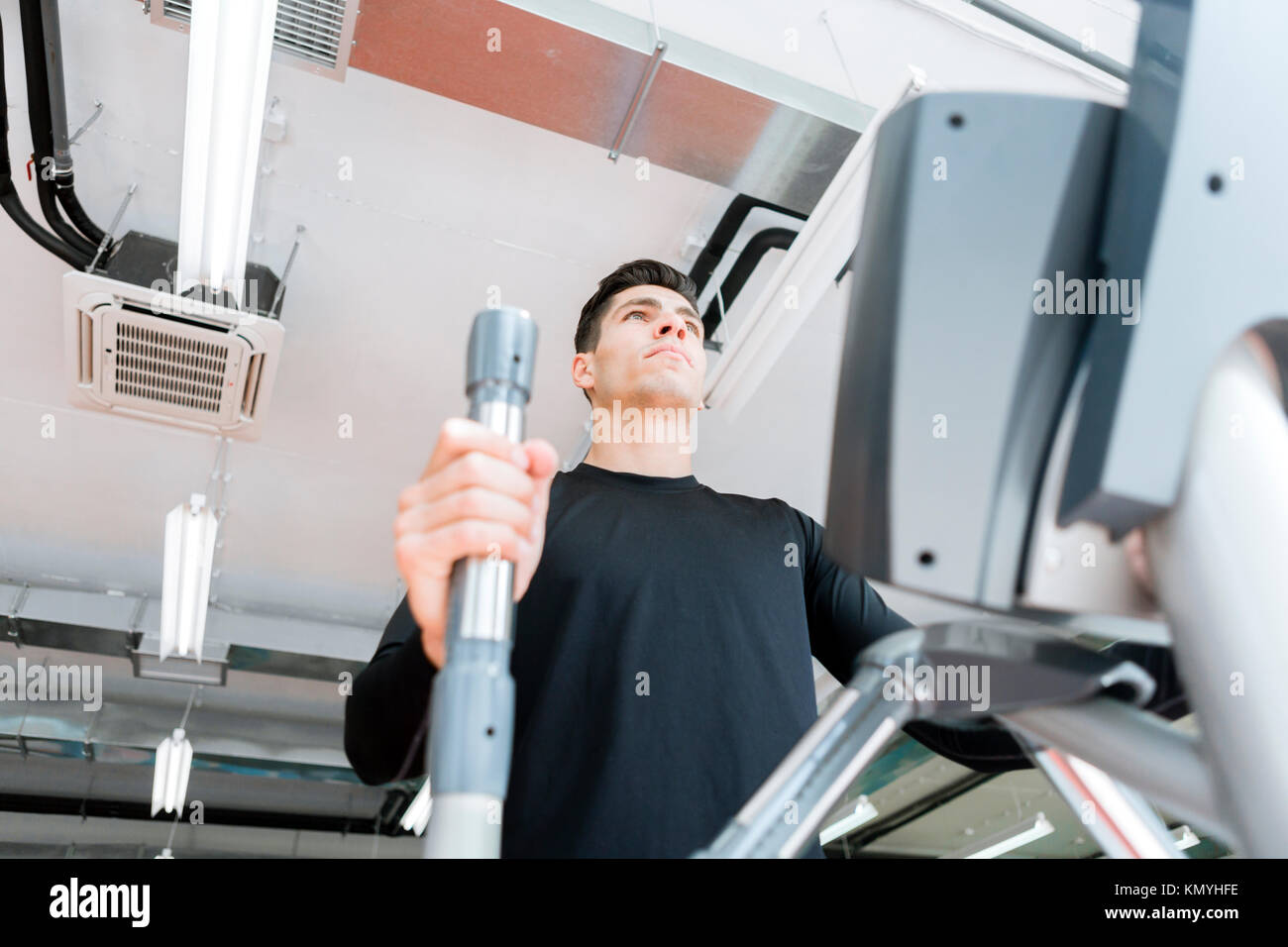 Young fit male working out on an elliptical trainer Stock Photo - Alamy