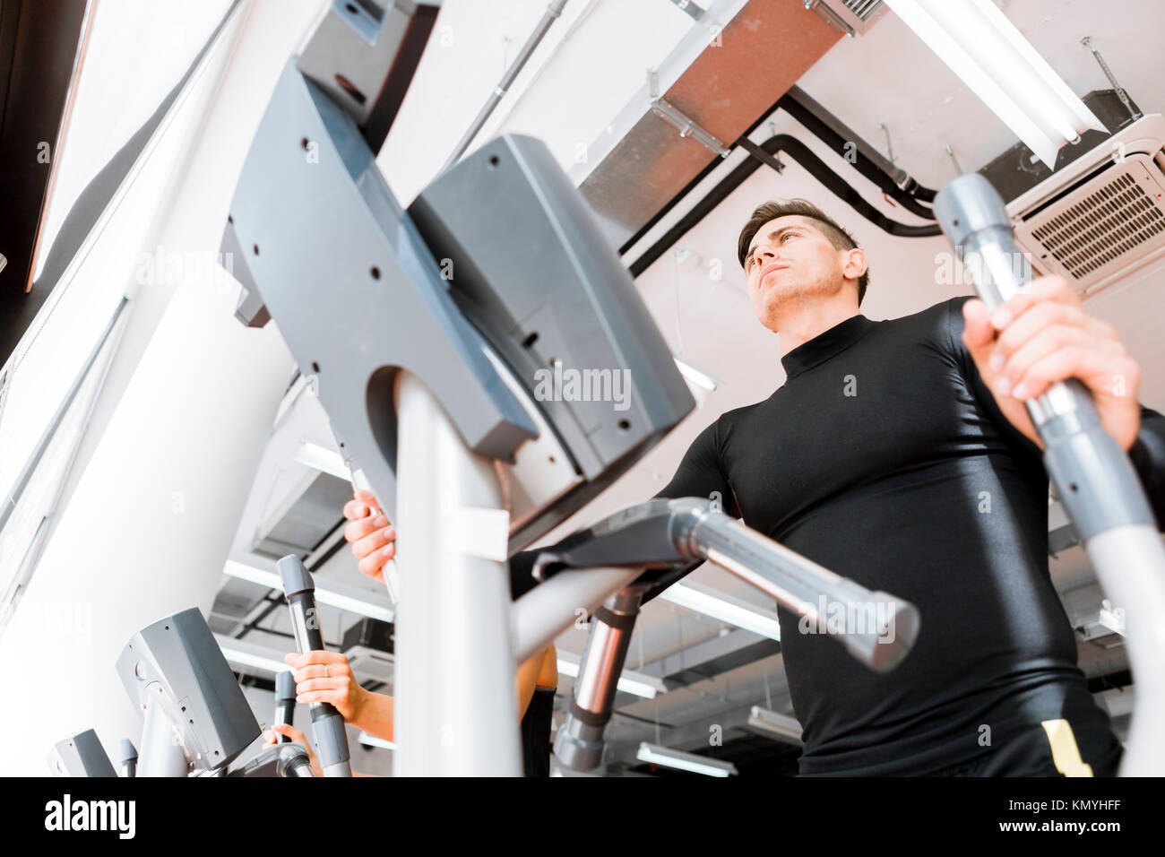 Young fit male working out on an elliptical trainer Stock Photo - Alamy