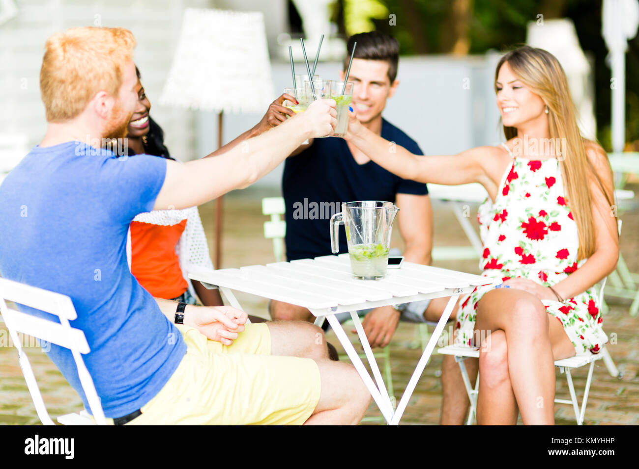 Group of cheerful happy people toasting while sitting at a table Stock ...