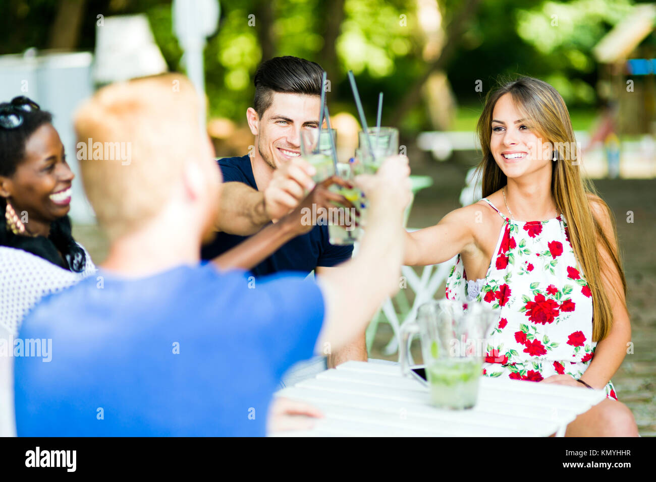 Group of cheerful happy people toasting while sitting at a table Stock ...