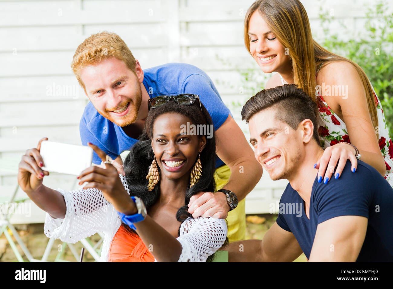 A group of friends sitting a table and talking smiling while ta Stock ...