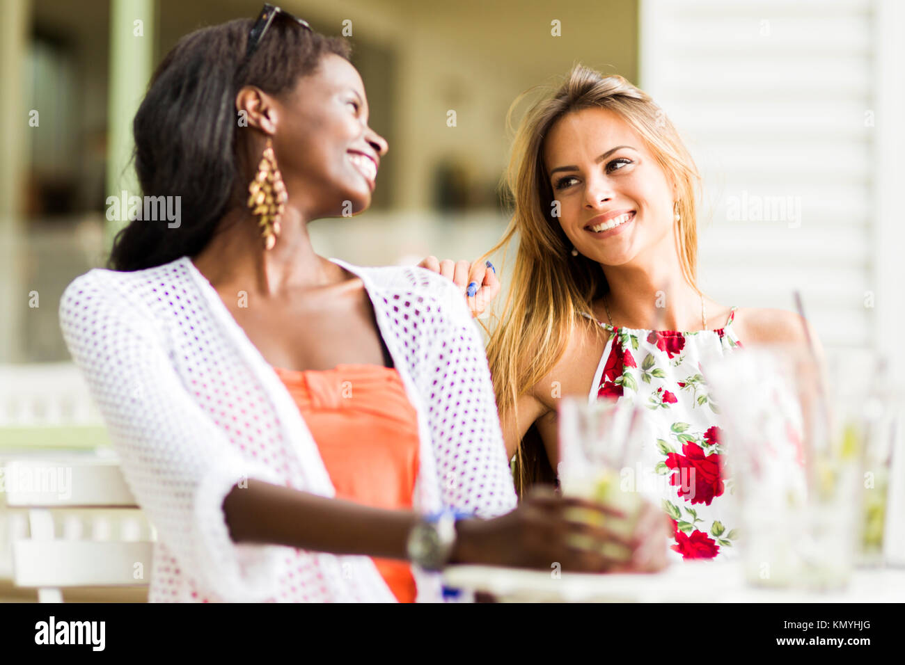 Young and happy friends sitting talking at a table Stock Photo - Alamy