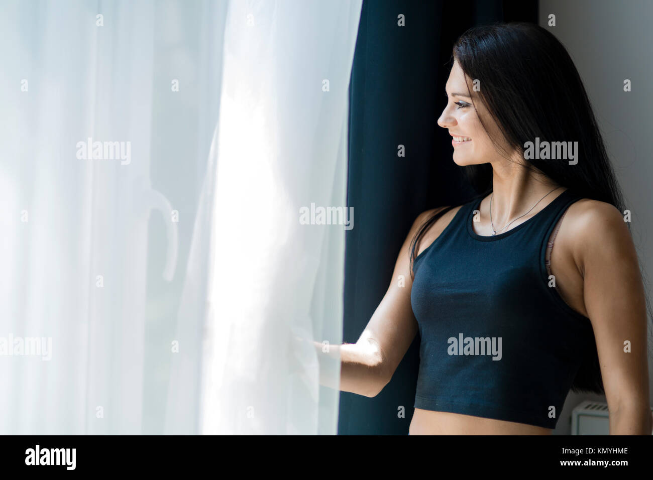 Happy beautiful woman staring out the window Stock Photo - Alamy