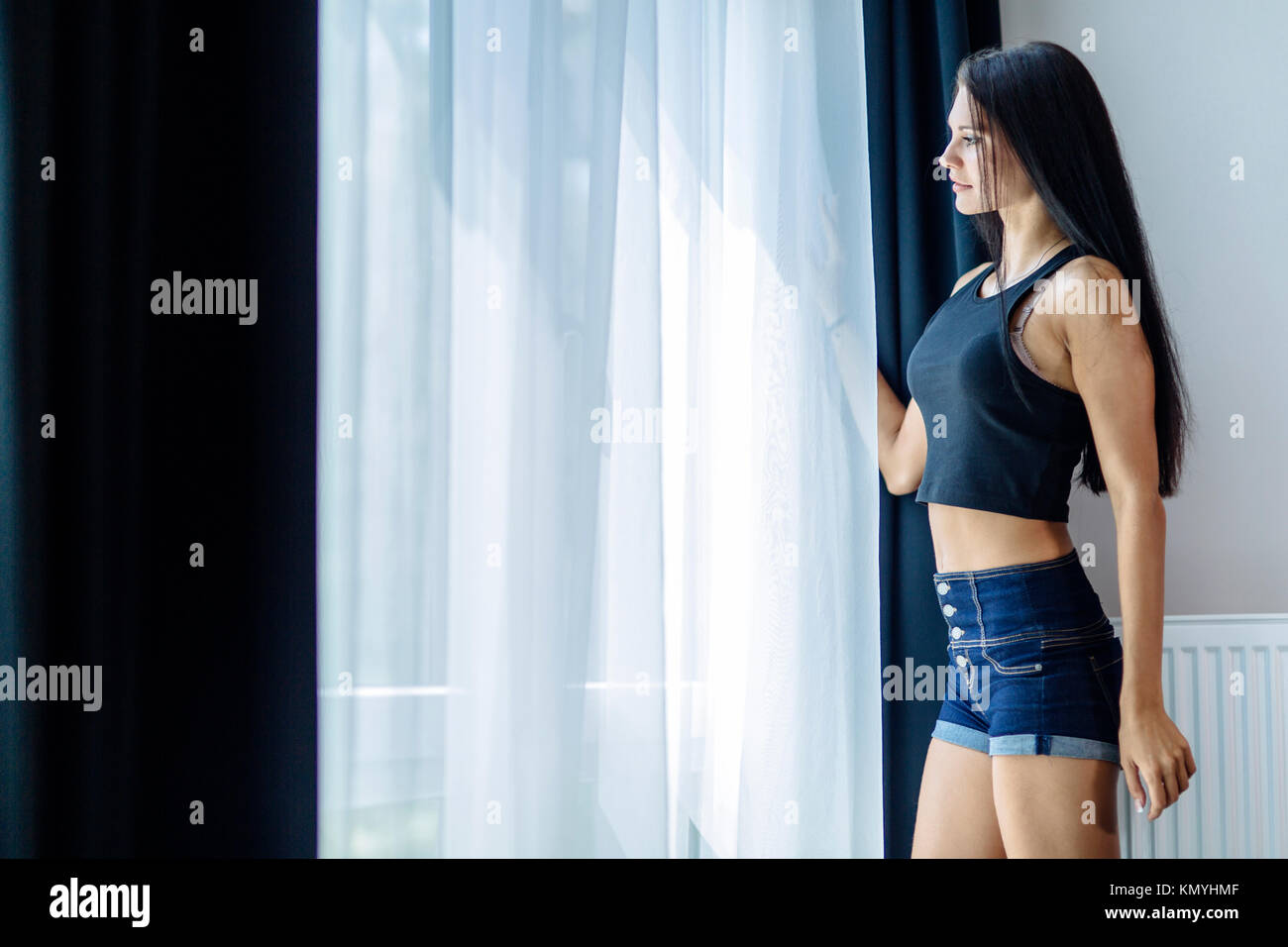 Happy beautiful woman staring out the window Stock Photo - Alamy