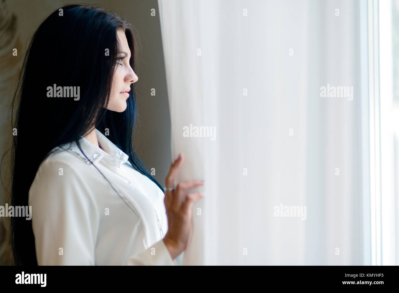 Happy beautiful woman staring out the window Stock Photo - Alamy
