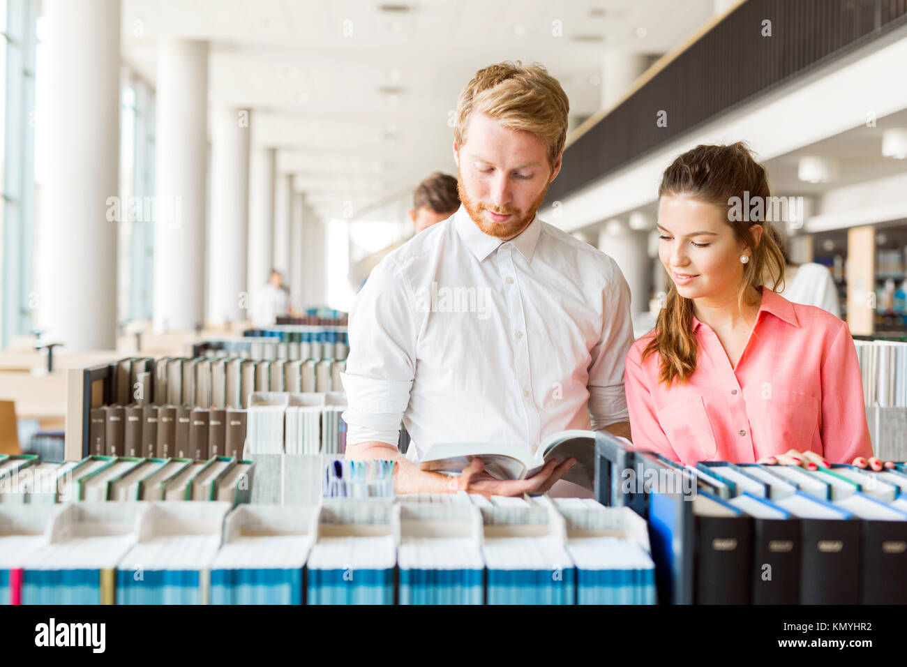 Two students reading and studying in library Stock Photo - Alamy