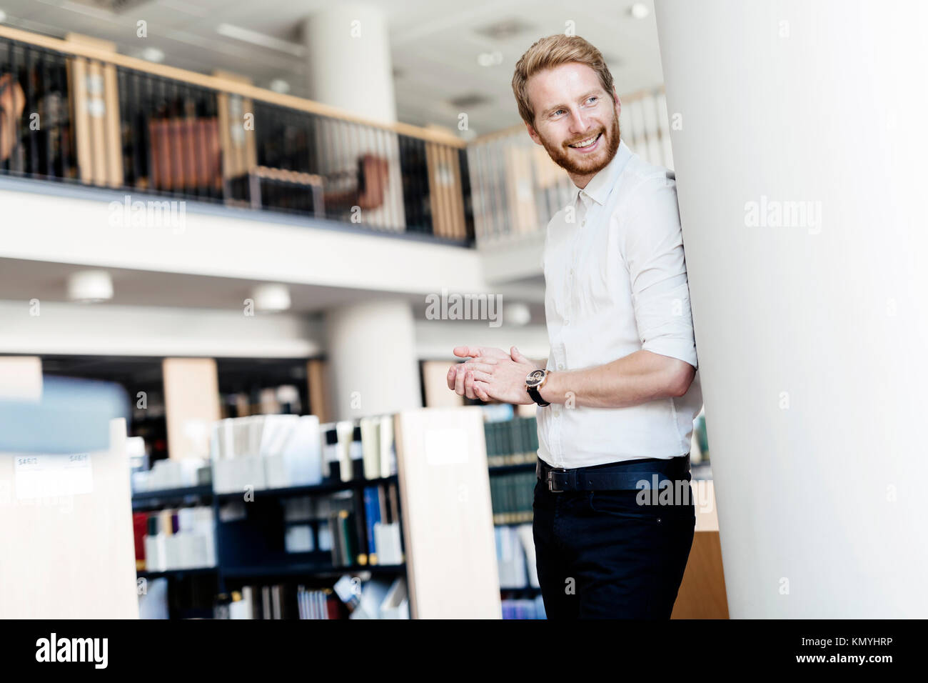 Student standing bookshelf smiling hi-res stock photography and images ...