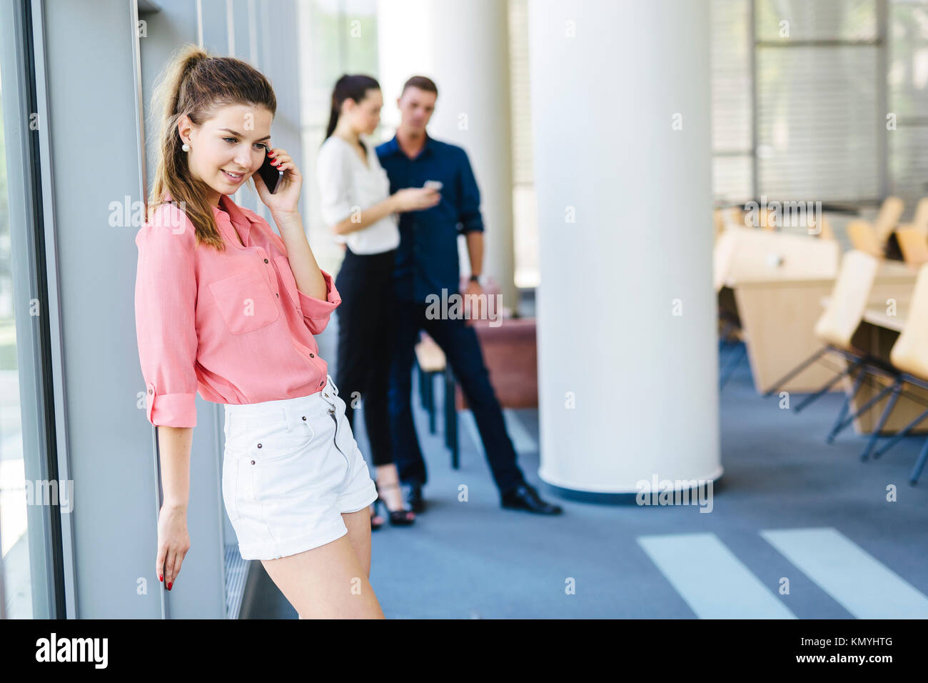 Beautiful women using phones and talkin during break Stock Photo - Alamy