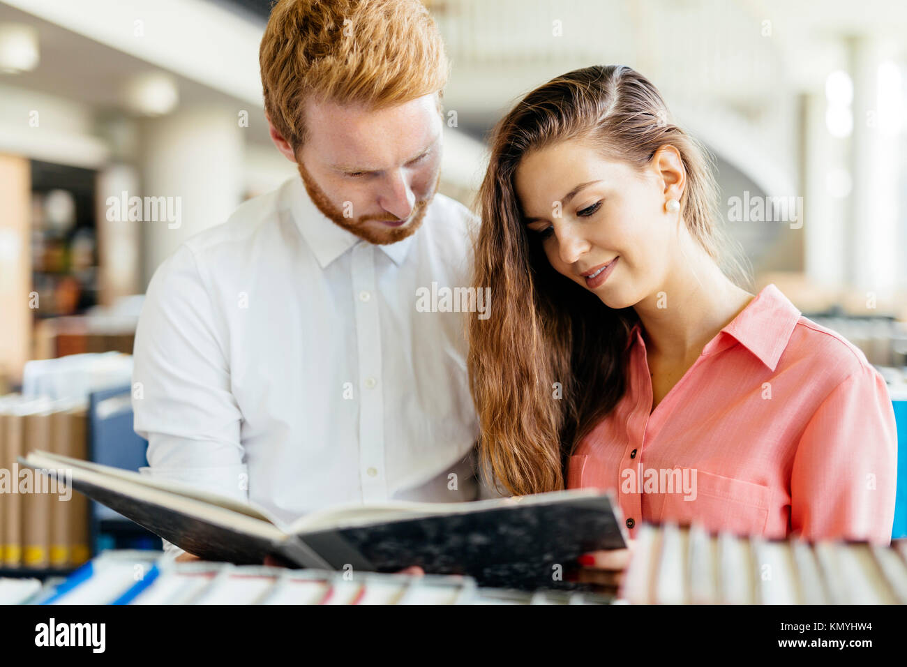 Two students reading and studying in library Stock Photo - Alamy