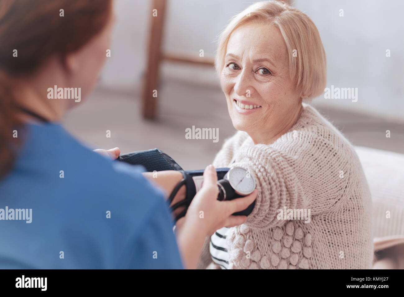 Happy retired lady smiling while checking her blood pressure Stock ...