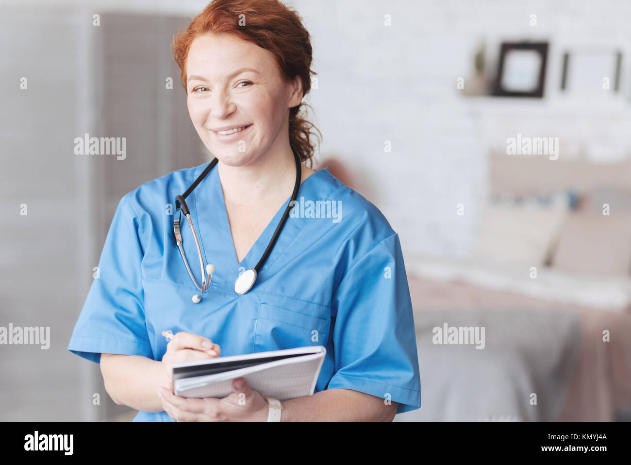 Friendly looking nurse with notebook smiling into camera Stock Photo ...