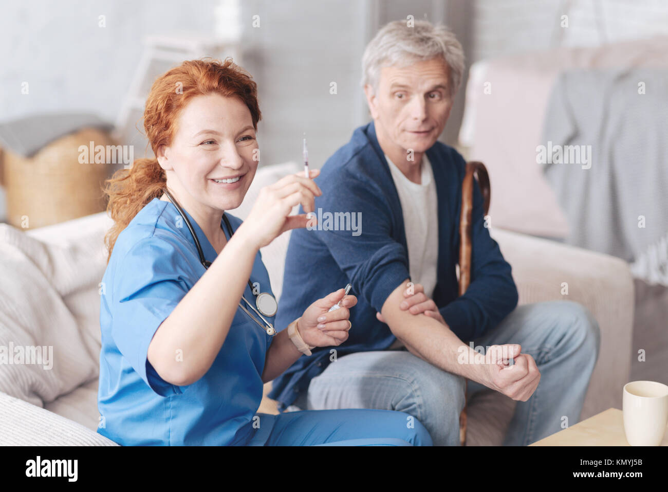 Radiant female medical worker with syringe preparing for injection ...