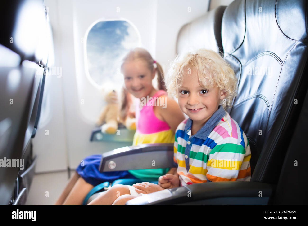 Child in airplane. Kids sit in air plane window seat. Flight ...