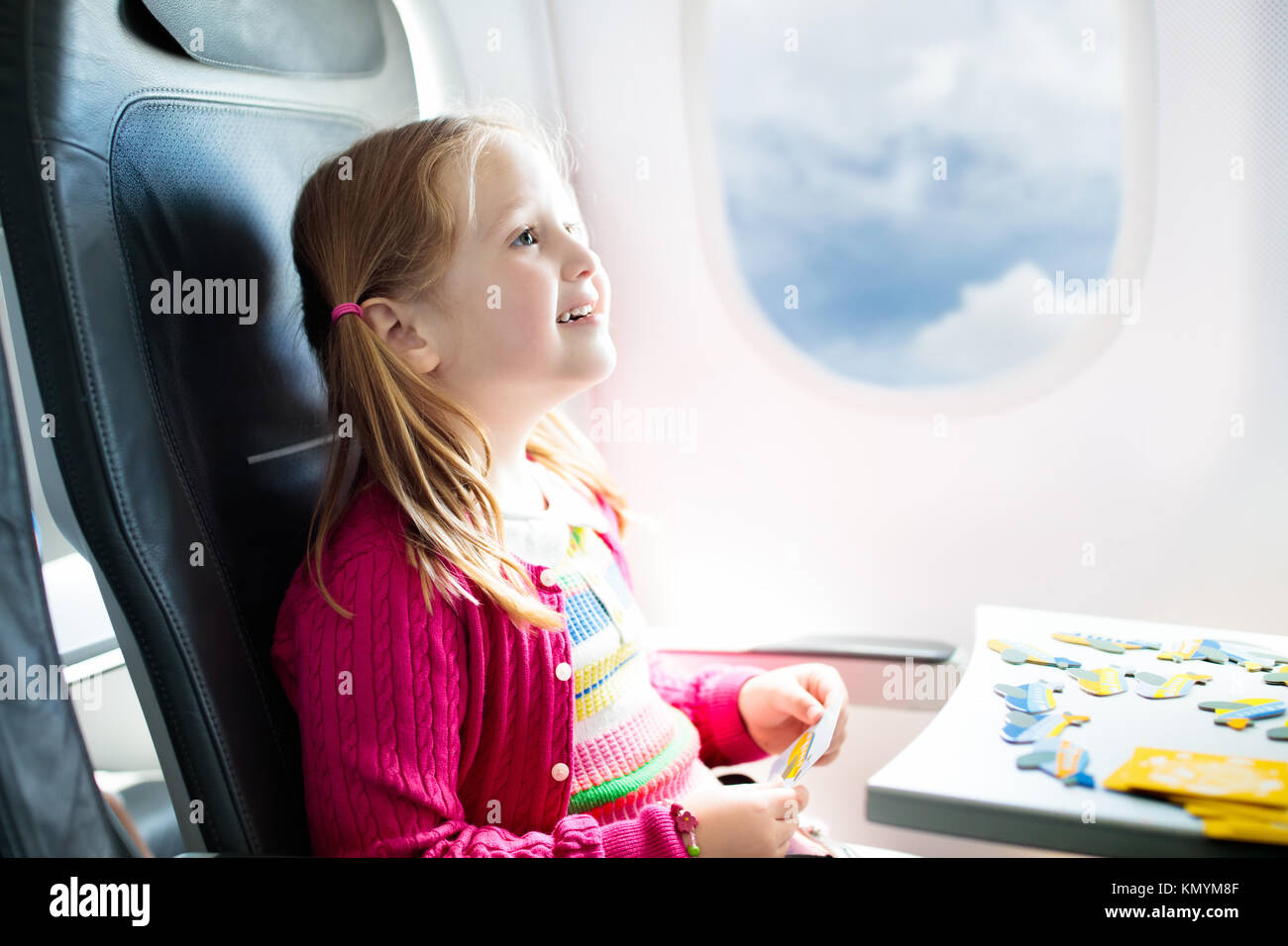 Child in airplane. Kid in air plane sitting in window seat. Flight ...
