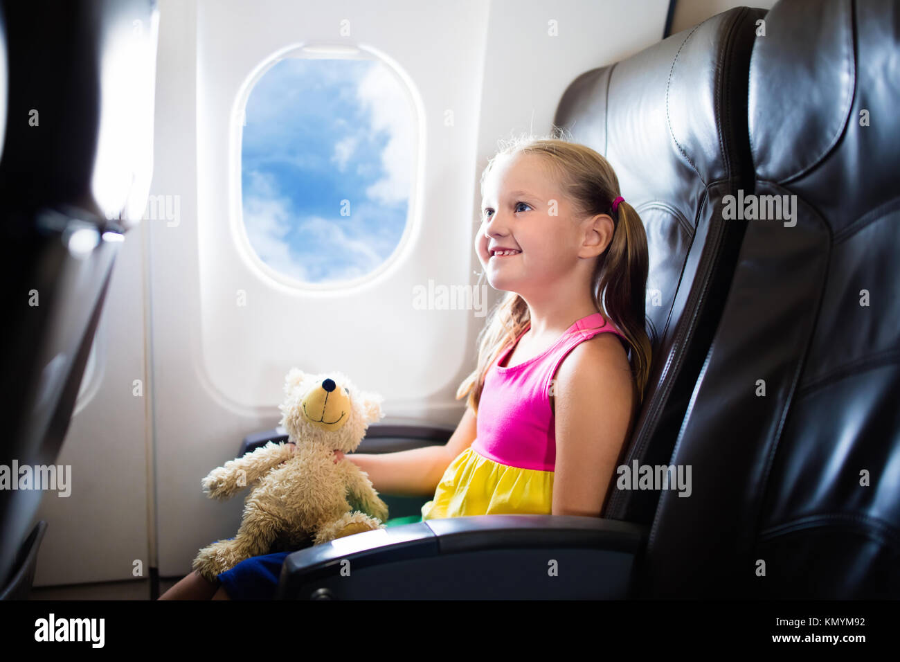 Child in airplane. Kid in air plane sitting in window seat. Flight ...