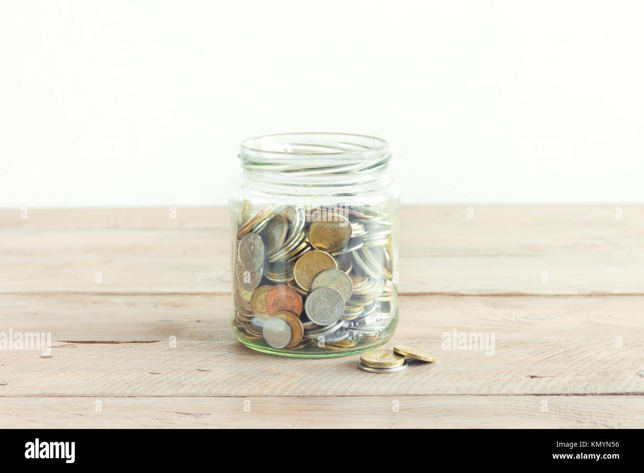 Coins in glass jar. Money savings concept. Jar with assorted coins on ...
