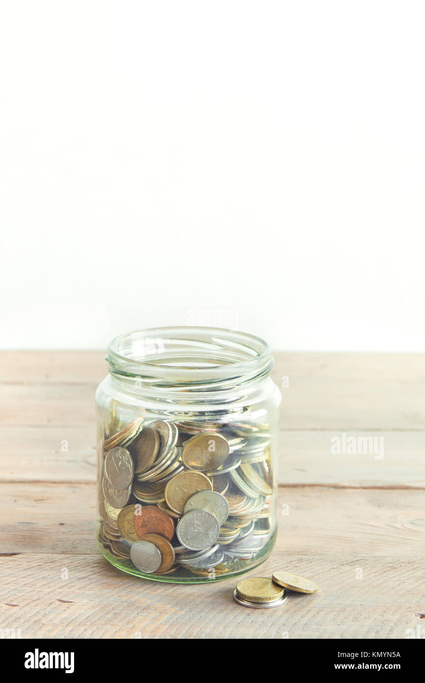 Coins in glass jar. Money savings concept. Jar with assorted coins on ...