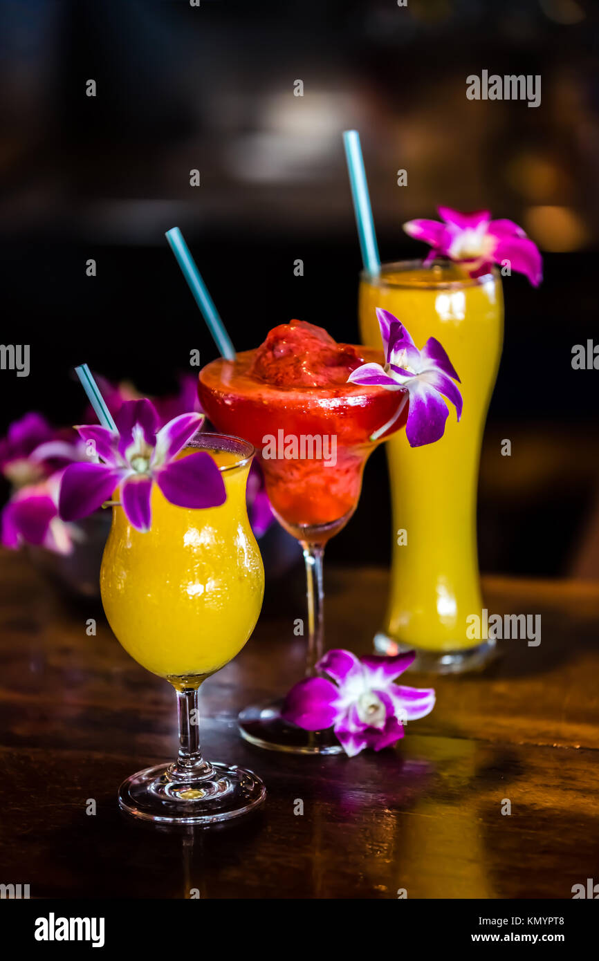 Composition with 3 yellow and red cocktails and orchid flowers on the ...