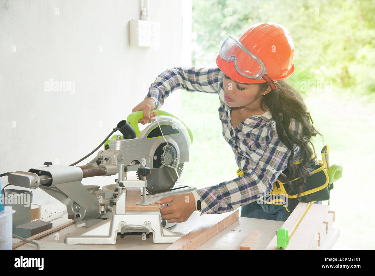 Pretty Asian female carpenter using Electric Sander cut a wood Stock ...