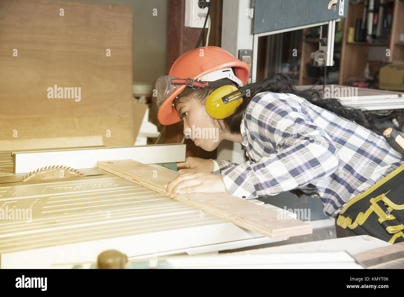 Pretty Asian female carpenter using Electric Sander cut a wood Stock ...