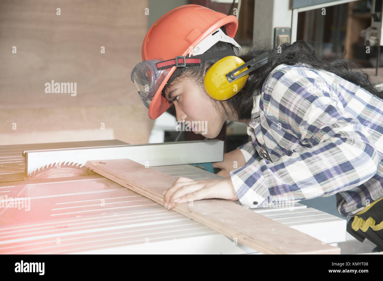 Pretty Asian female carpenter using Electric Sander cut a wood Stock ...