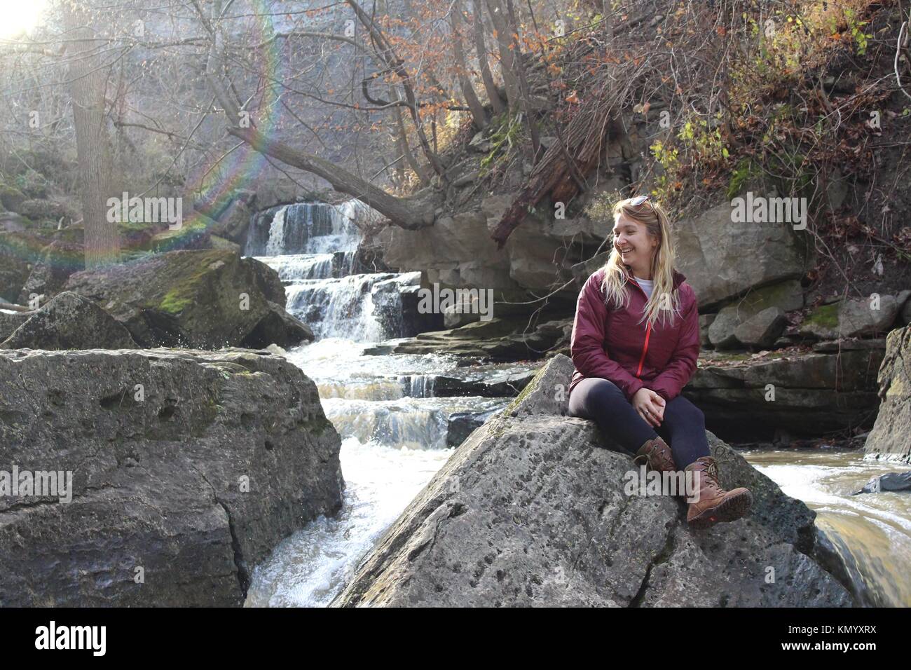 Girl sat on rock in the middle of waterfall hi-res stock photography ...