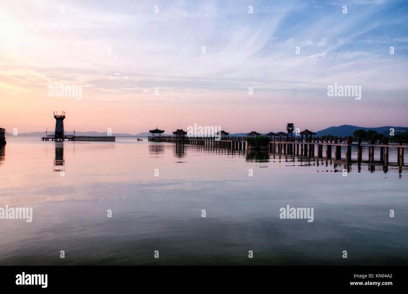 A long pier and asian covered gazebos over the water of Tai Lake at the ...