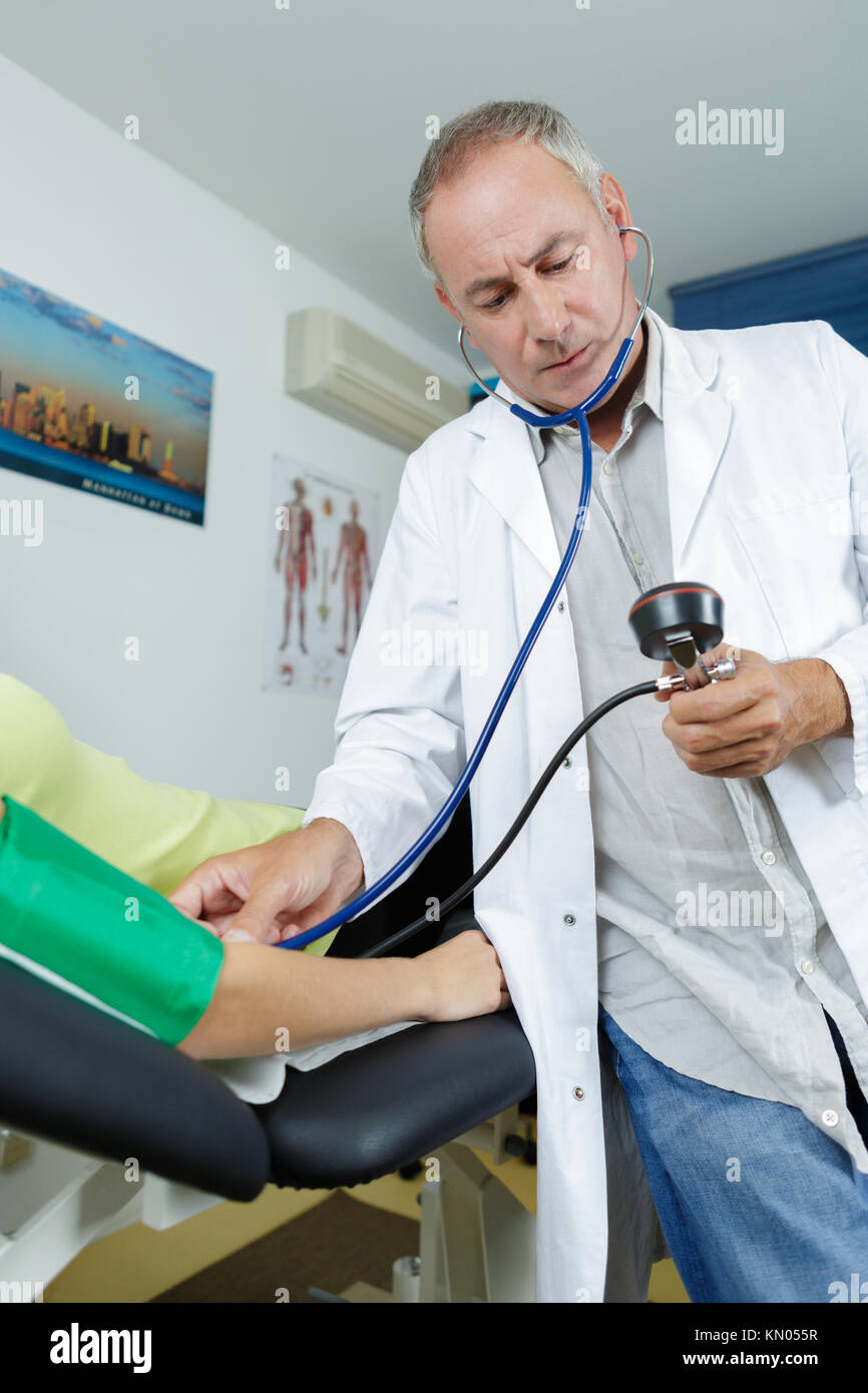 Doctor concentrating on blood pressure gauge Stock Photo - Alamy