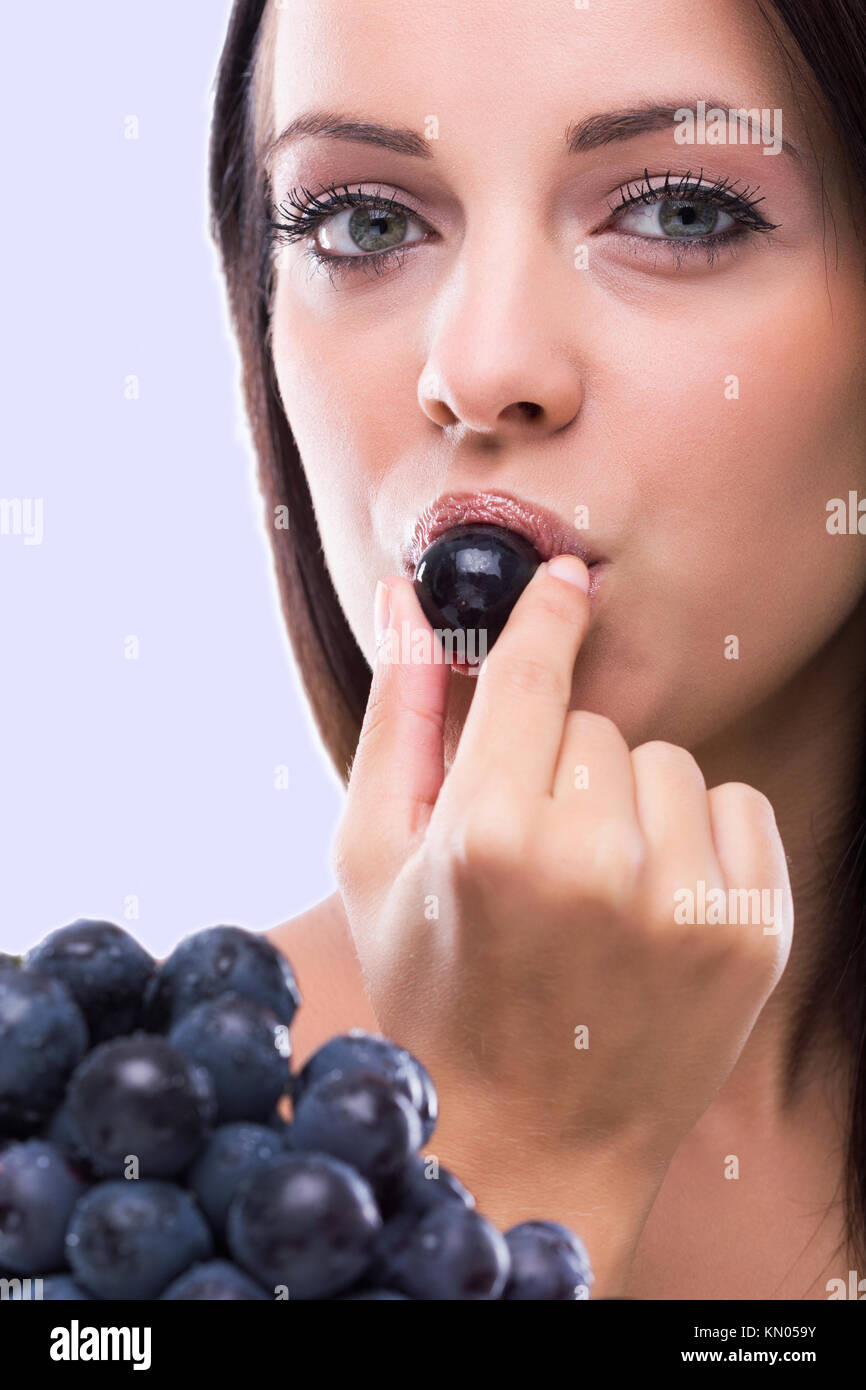 Beautiful woman eating fresh grapes Stock Photo - Alamy