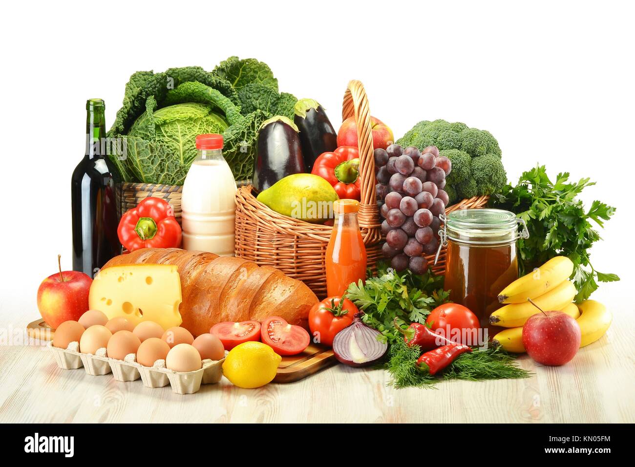 Groceries in wicker basket including vegetables, fruits, bakery and ...