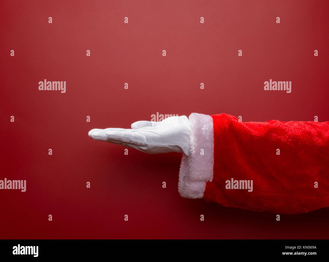 Santa Claus open his hand on red background Stock Photo - Alamy
