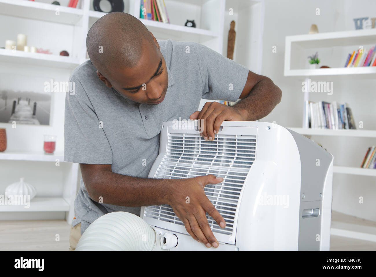 Man fixing fan Stock Photo - Alamy