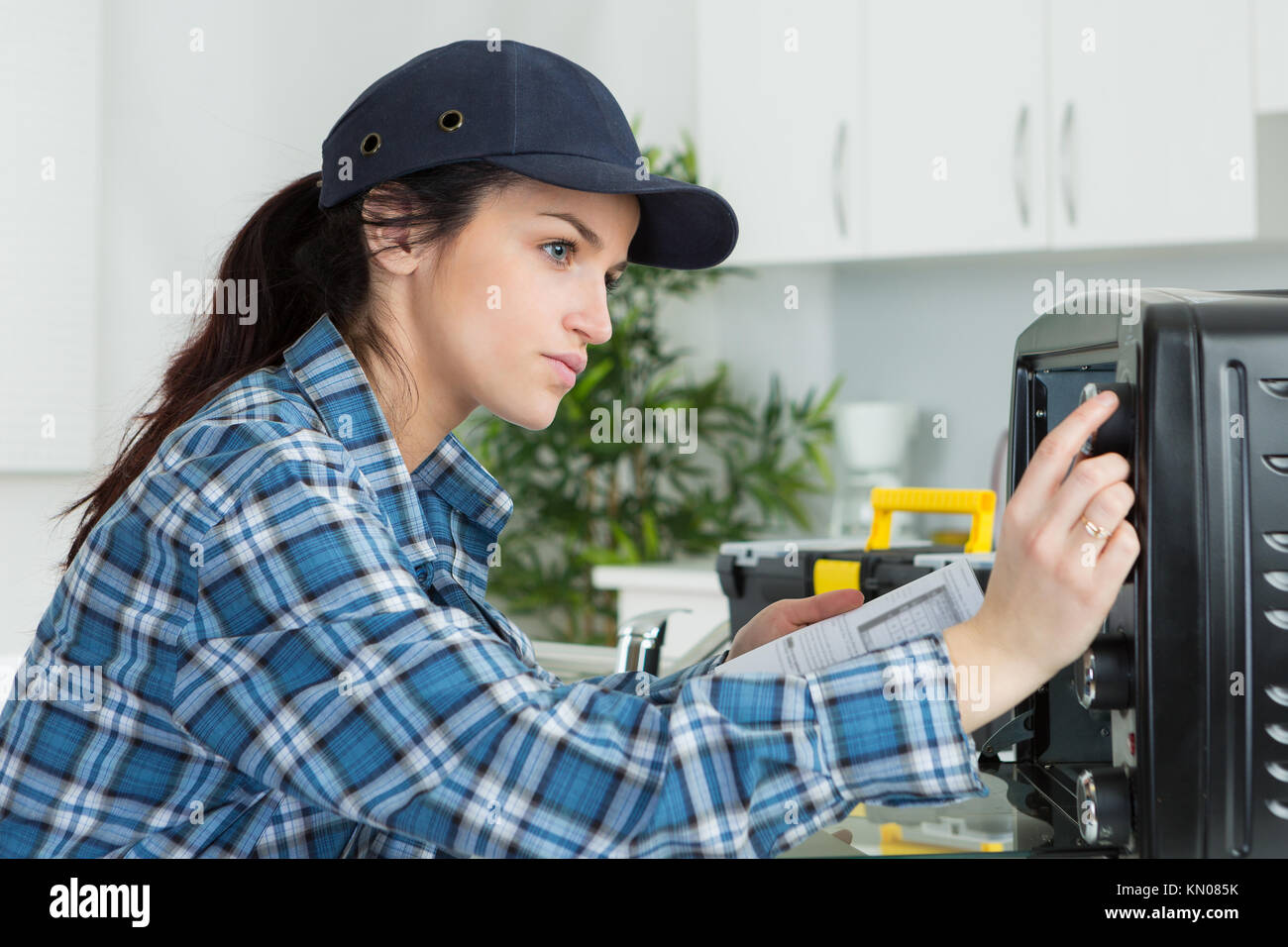 Female electrician working on household appliance Stock Photo - Alamy