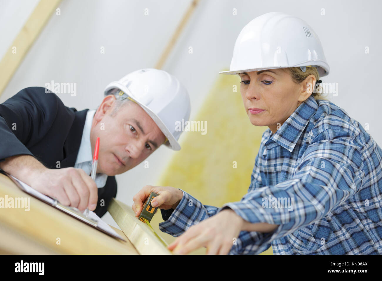 mature male architect and female carpenter at construction site Stock ...